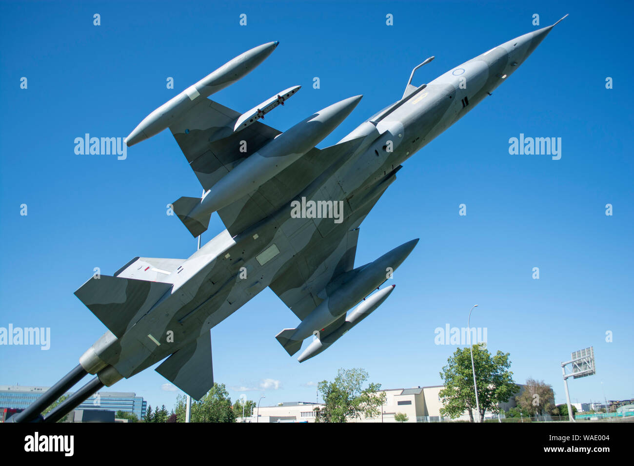 Fighter jet mounted for outdoor display. Against blue sky with upward ...