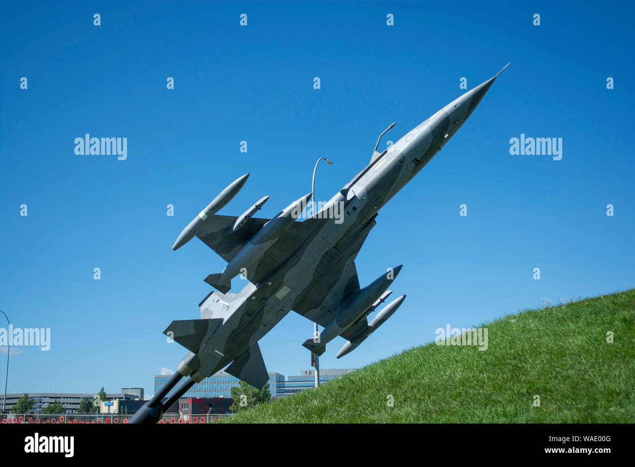 Fighter jet mounted for outdoor display. Against blue sky with upward ...