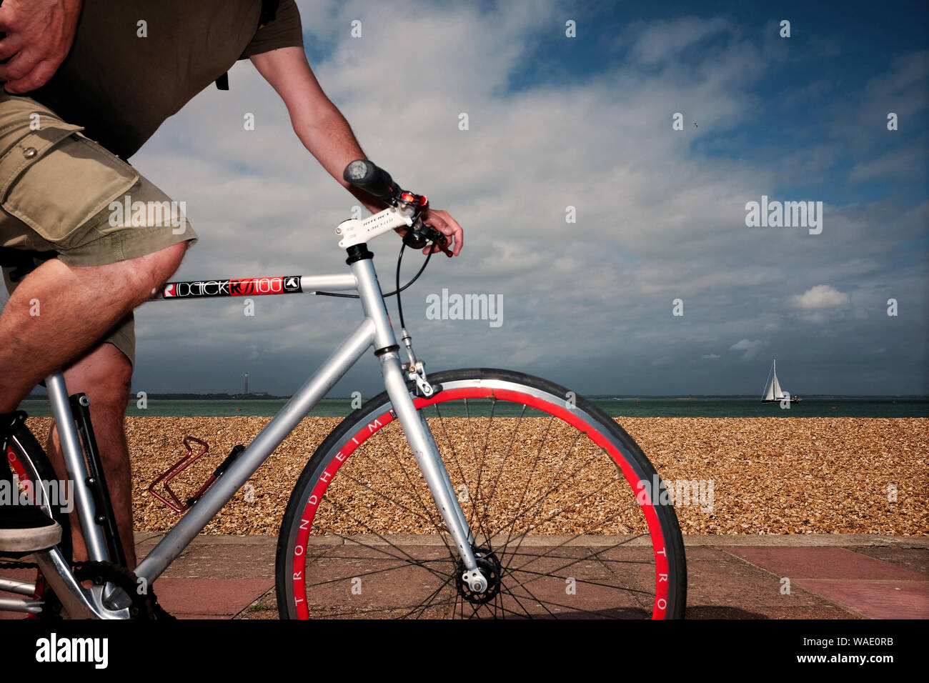 A cyclist cycling along the promenade at Cowes seafront on the Isle of ...