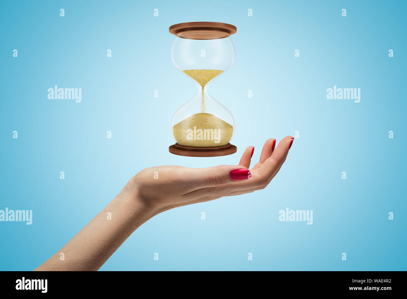 Side closeup of woman's hand facing up and levitating hourglass on ...
