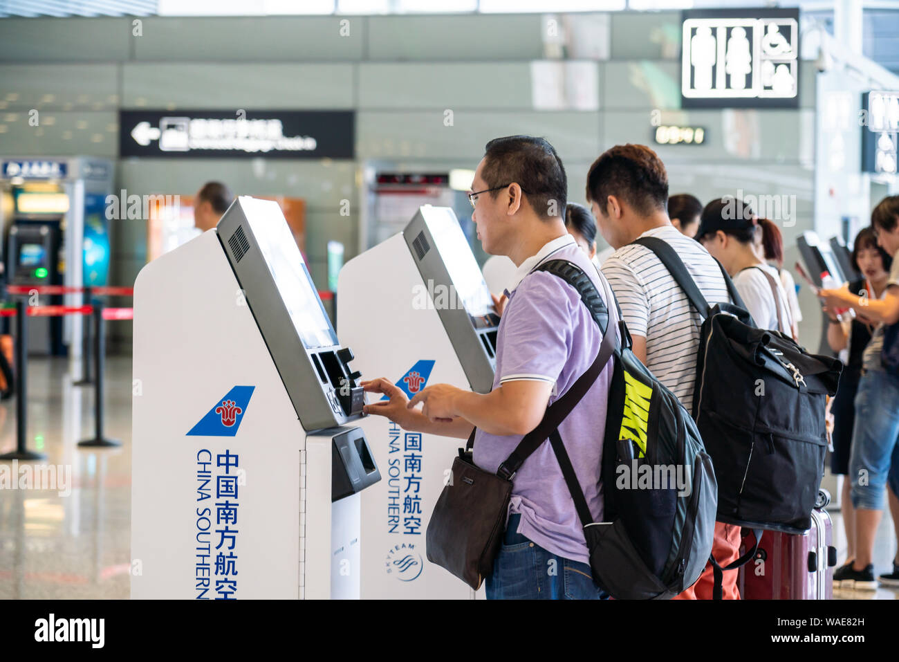 Passengers use the China Southern Airlines kiosks for airport check-in ...