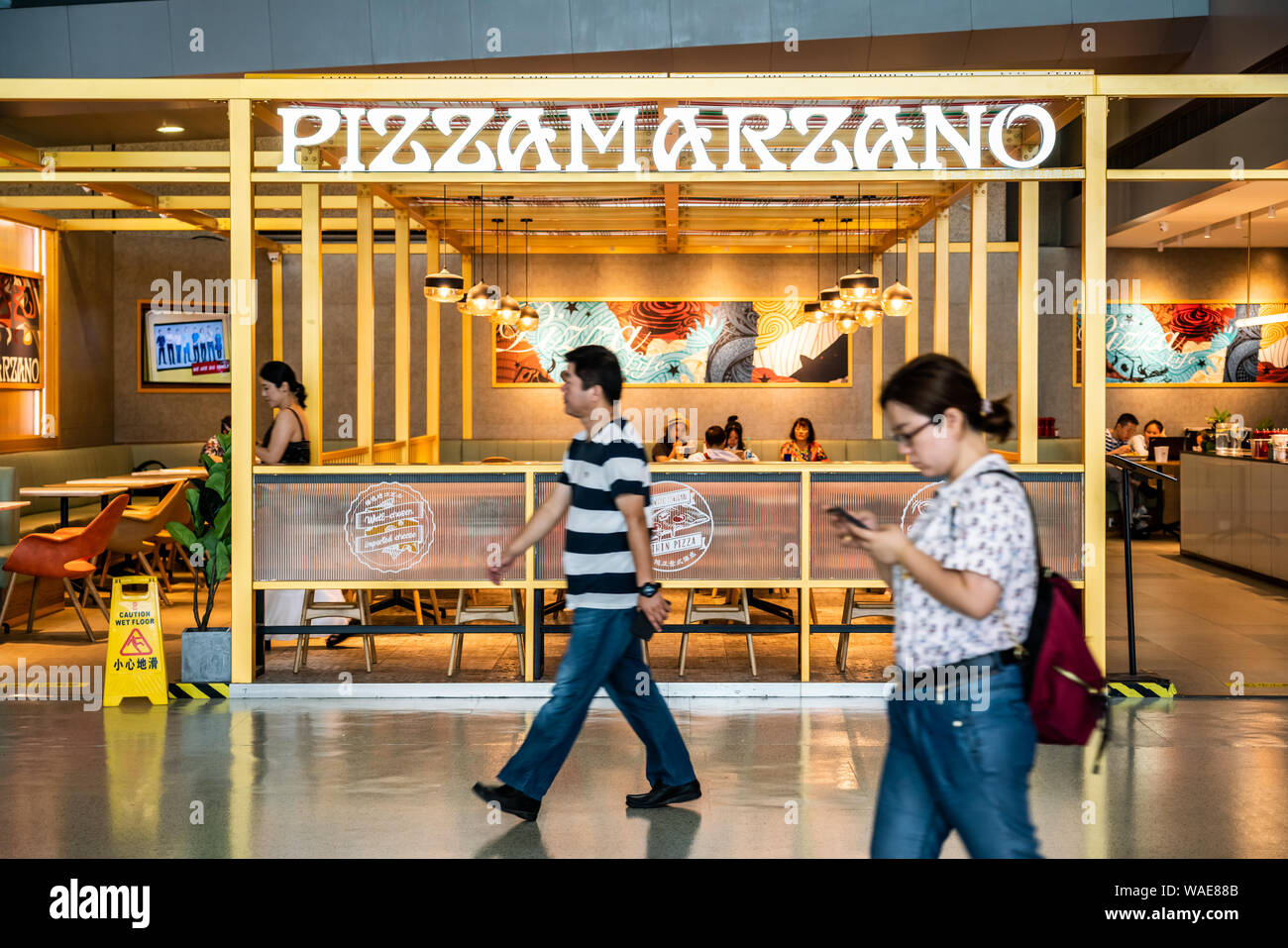 Pedestrians walk past a Pizza Marzano restaurant in Shanghai Hongqiao ...