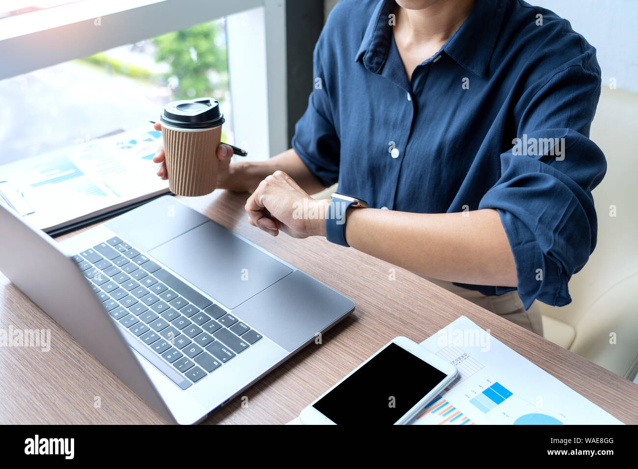 Business man working with graph data in laptop and documents on his ...