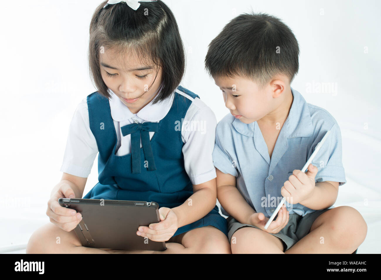 Boy and girl learning by tablet computer Stock Photo - Alamy