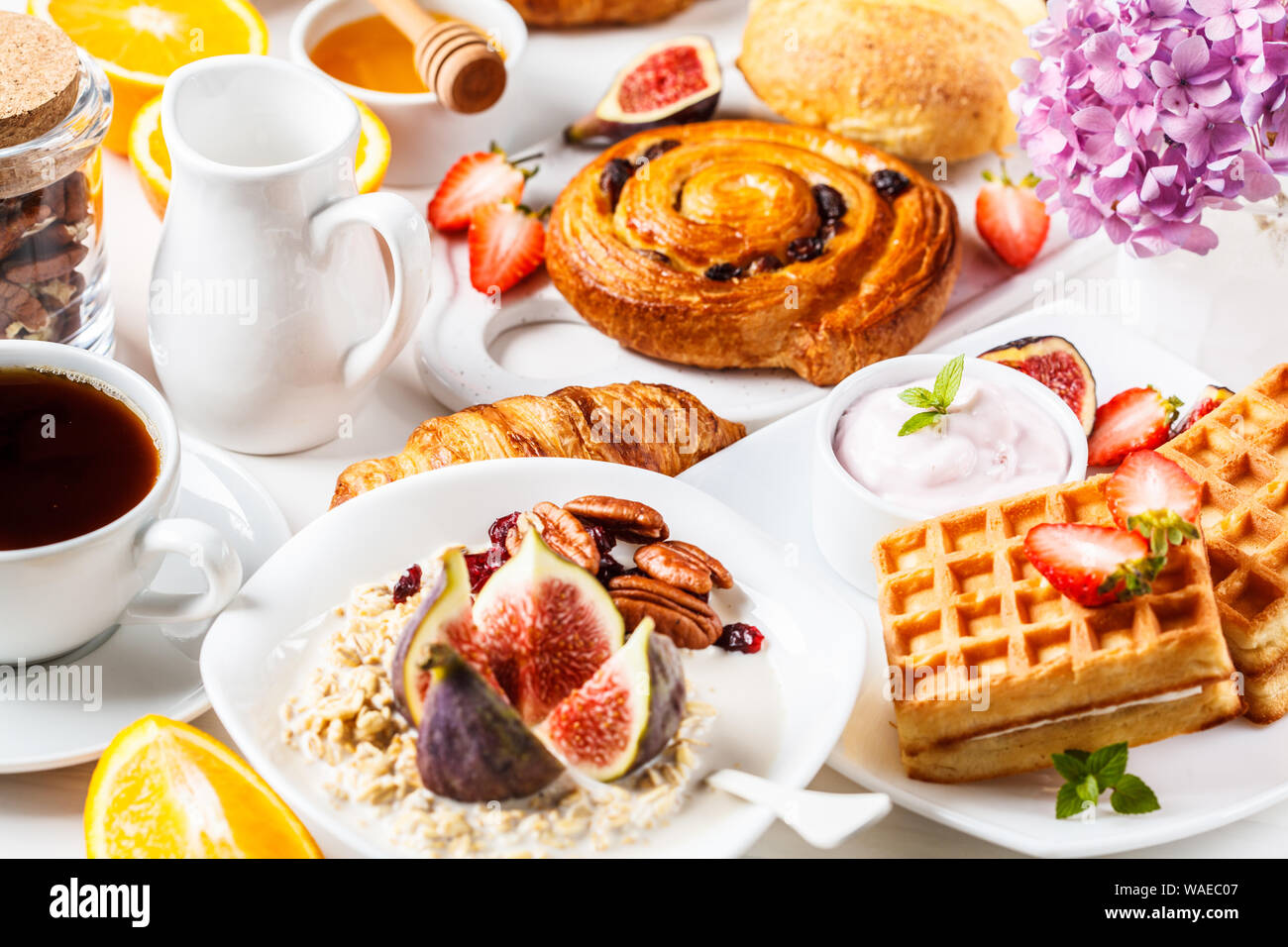 Breakfast table with oatmeal, waffles, croissants and fruits. White ...