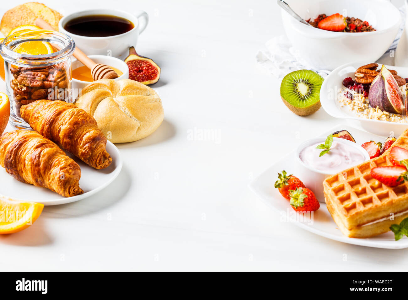 Breakfast table with oatmeal, waffles, croissants and fruits. White ...