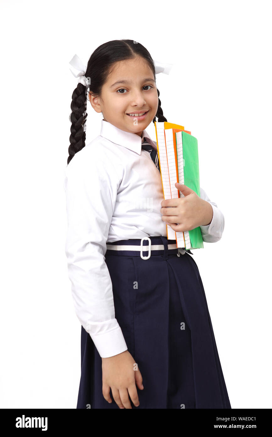Schoolgirl standing with books and smiling Stock Photo - Alamy