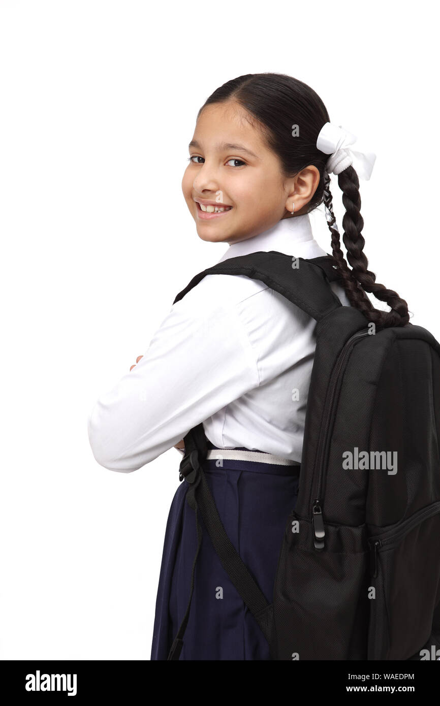 Indian schoolgirl standing with backpack and smiling Stock Photo - Alamy