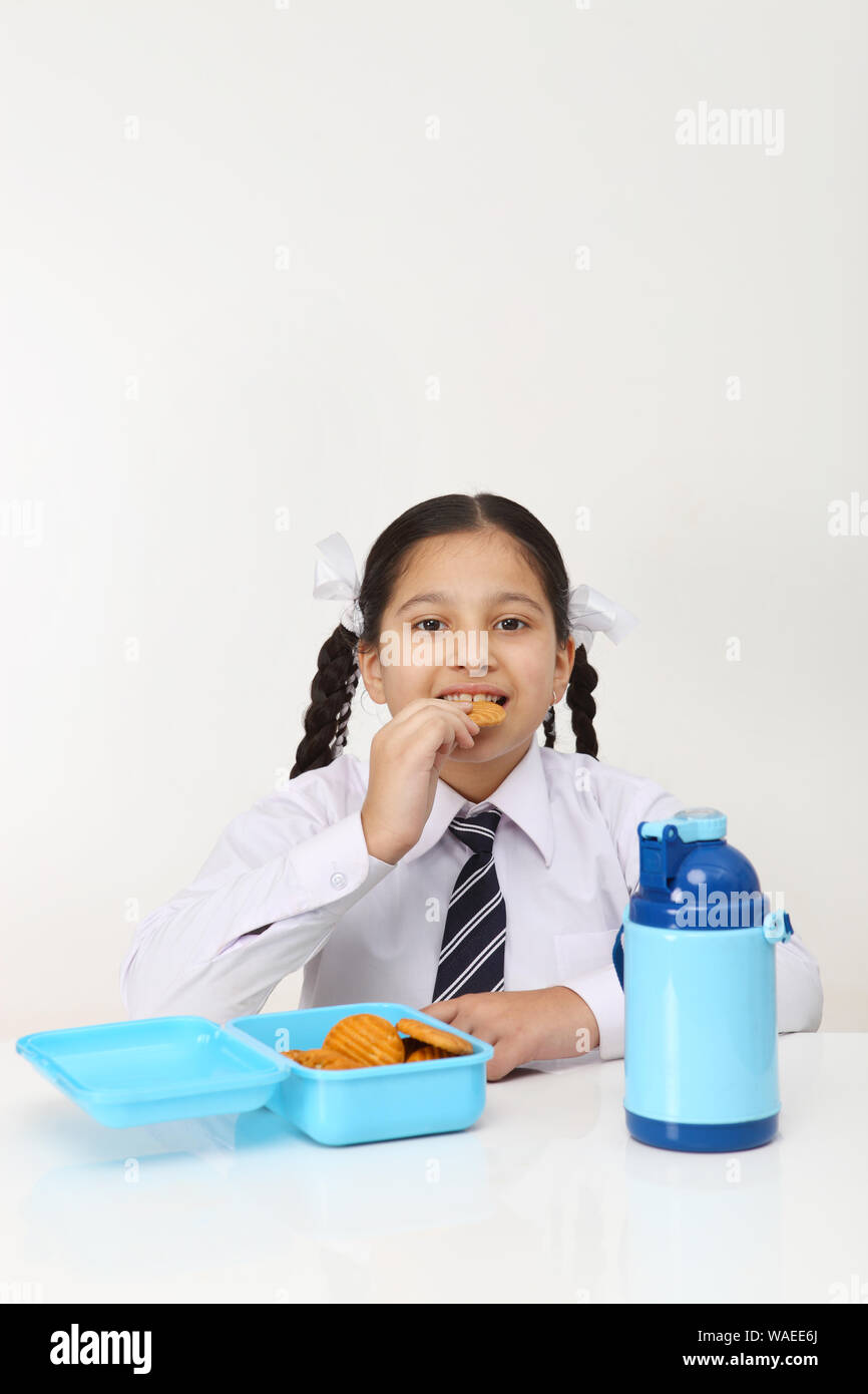 Schoolgirl eating lunch in classroom Stock Photo - Alamy