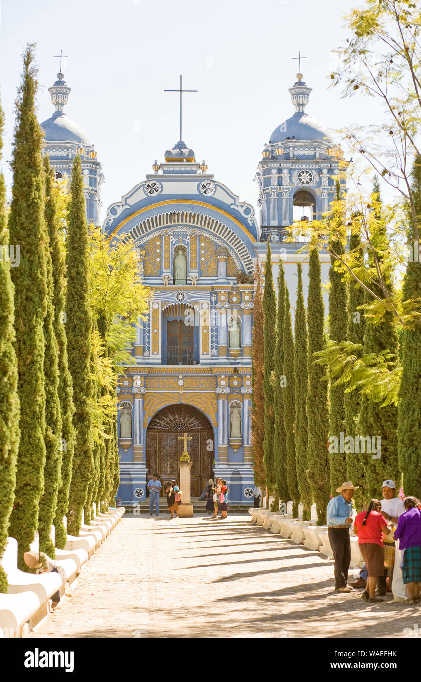 Mexican people socializing outside village church painted in typical ...