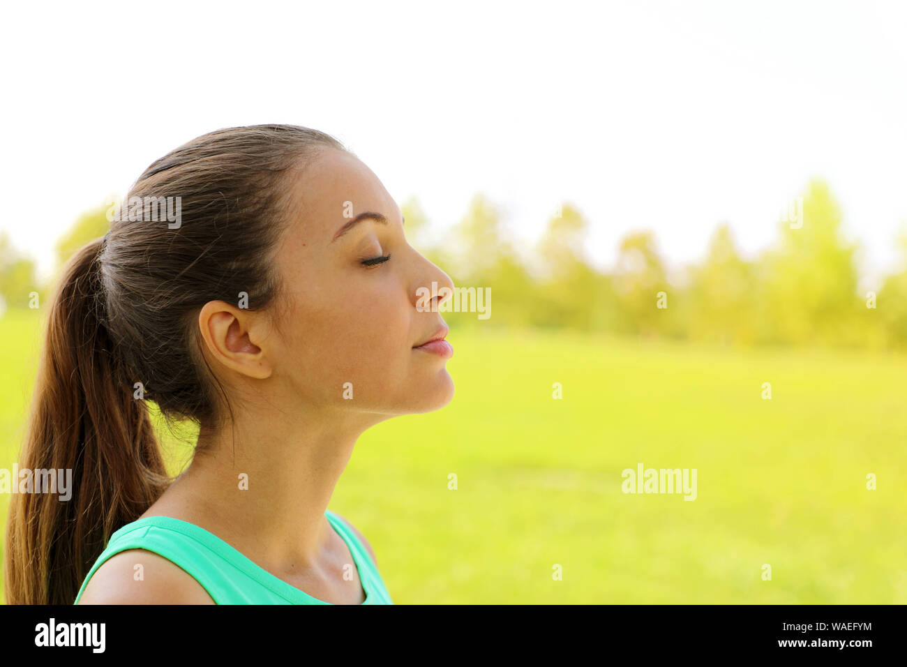 Side view portrait of woman relaxing breathing fresh air deeply in the ...