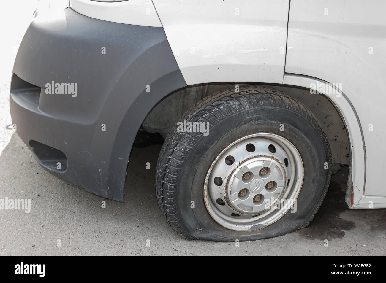 Car wheel flat tire on the road. Small white truck with punctured wheel ...
