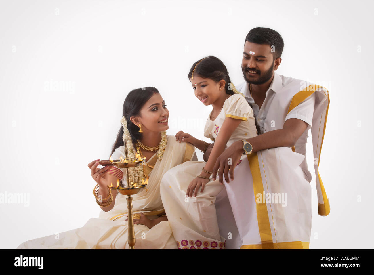 south indian woman lighting lamp with a diya on onam Stock Photo - Alamy