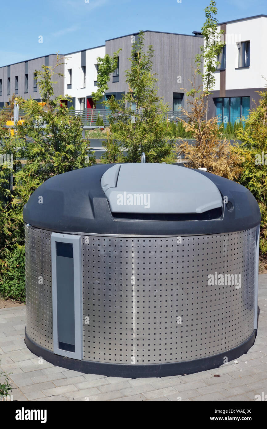 A new large modern stainless steel trash bin is installed on a city ...
