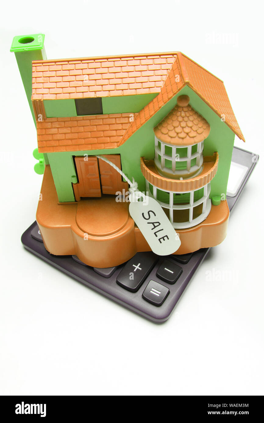 Dream home with sale tag on calculator Stock Photo - Alamy