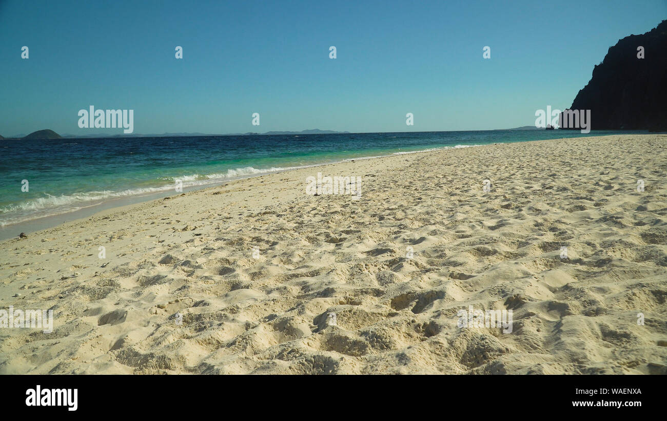 Tropical sandy beach and blue sea with waves. Malajon Island ...