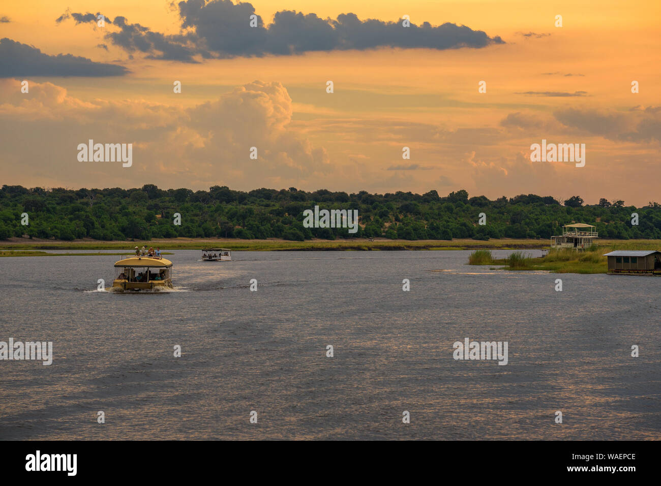 People on a sunset safari cruise on Chobe River in Chobe National Park ...