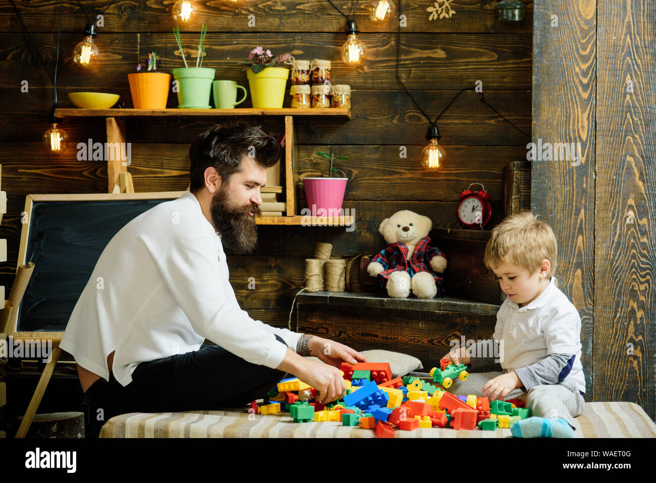Construction concept. Father and child play with toy construction set ...