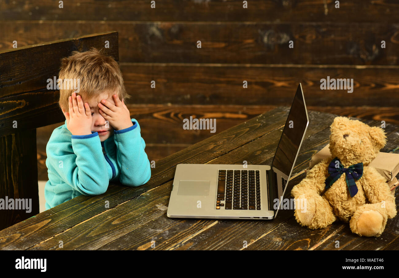 Elearning concept. Little child got tired of elearning with laptop ...