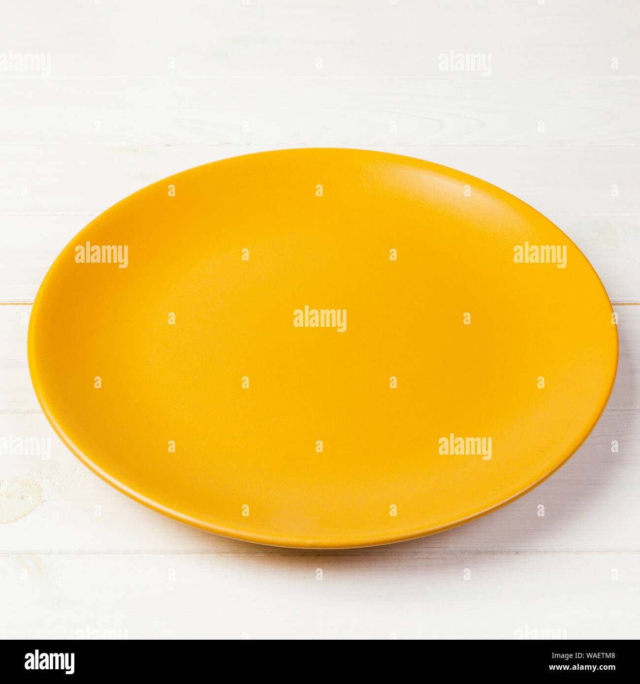Yellow Round Plate on wooden table background. Top view, template for ...