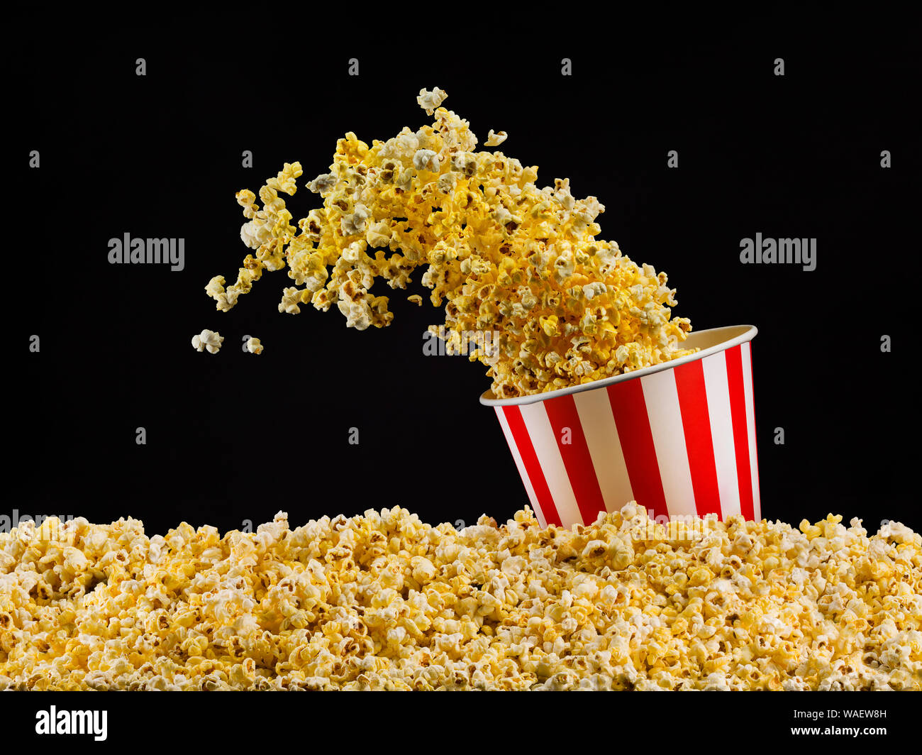 Flying popcorn from striped bucket isolated on black background Stock ...