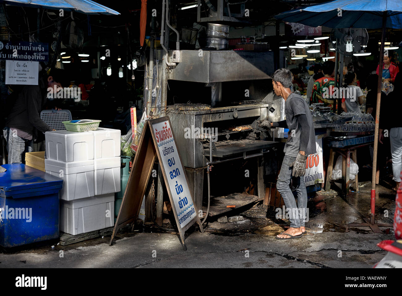 Man cooking. BBQ chef cooking on an open range in a Thailand street ...