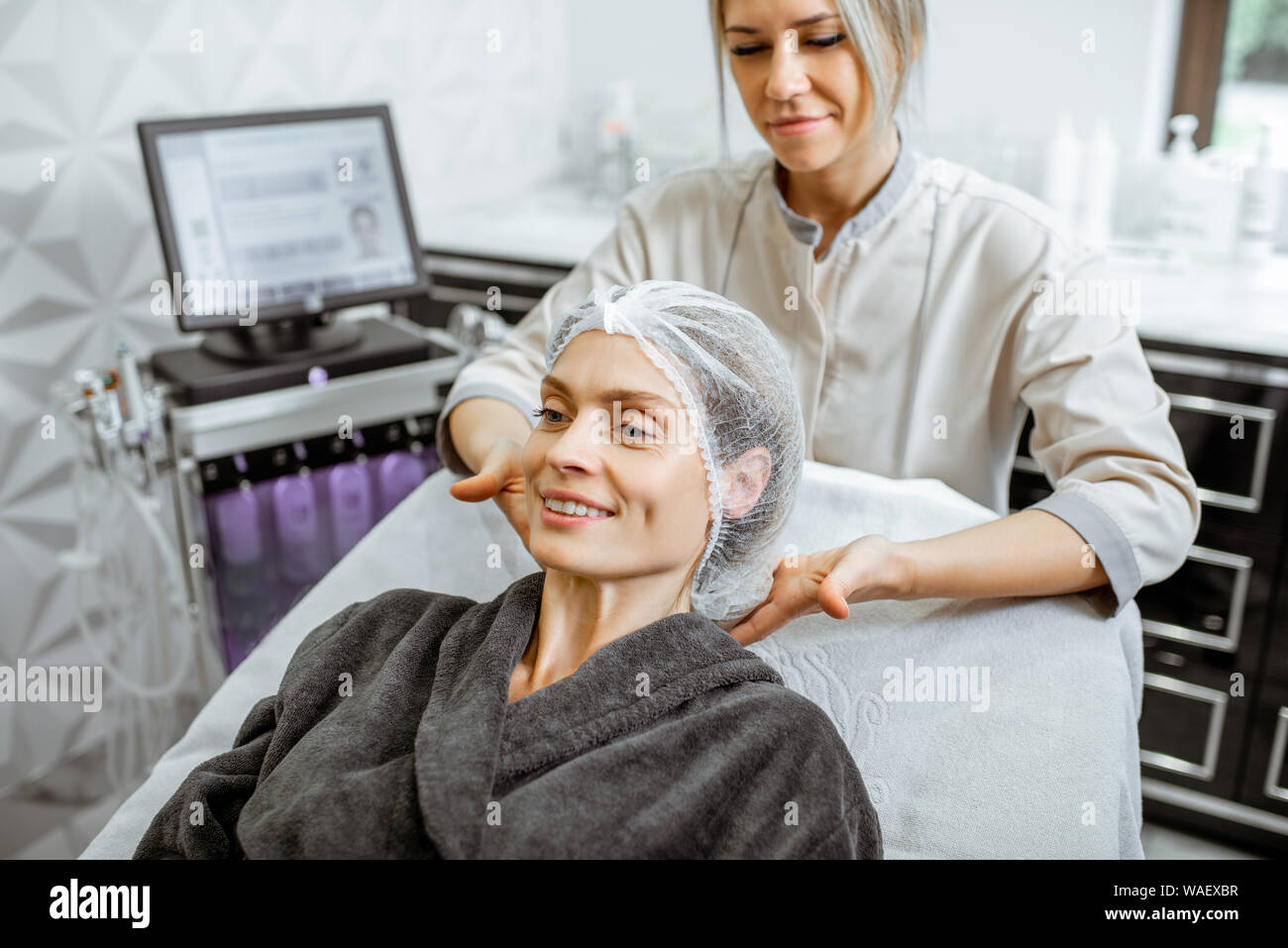 Cosmetologist carefully putting client's head on the couch before the ...