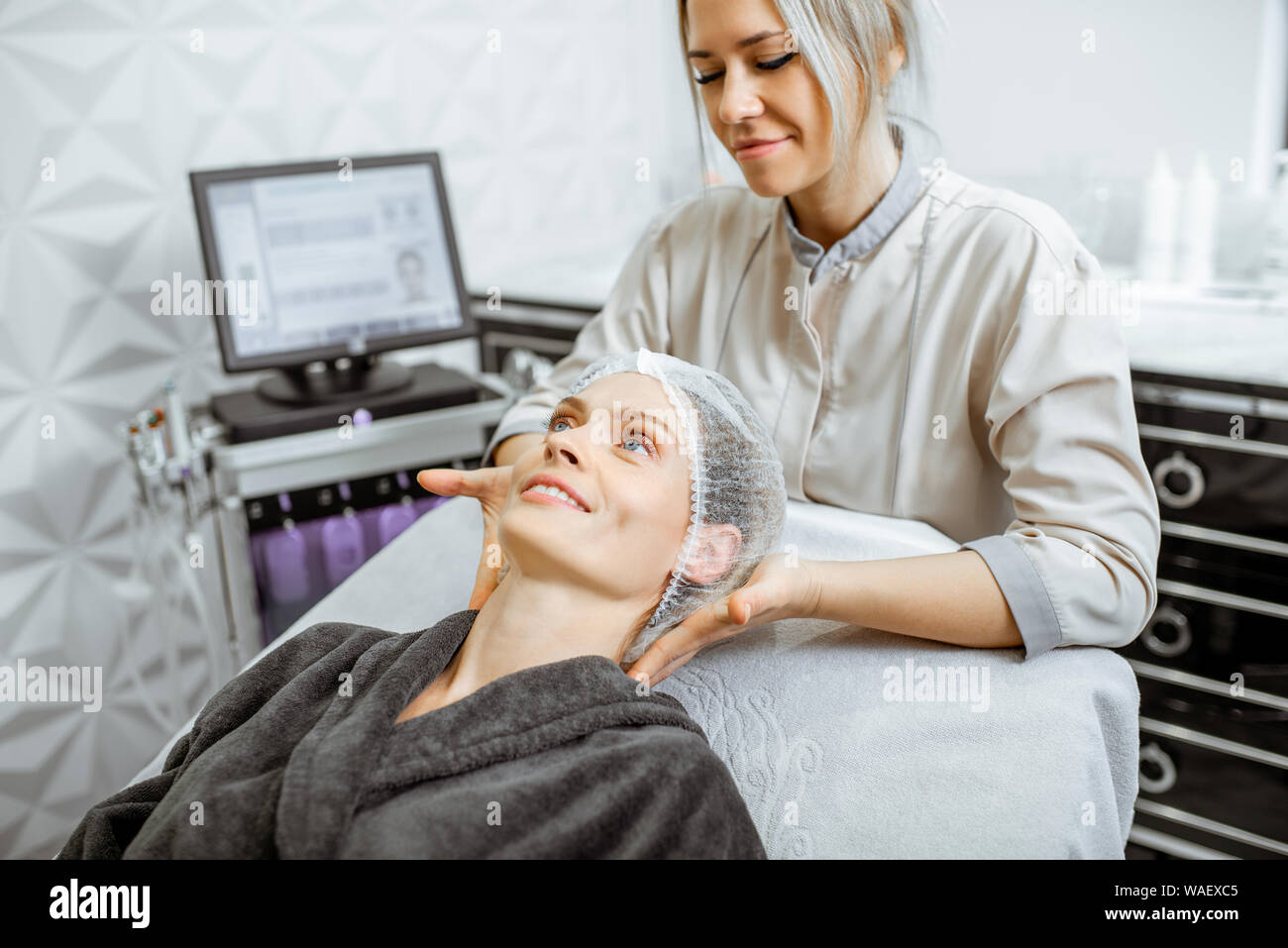 Cosmetologist carefully putting client's head on the couch before the ...