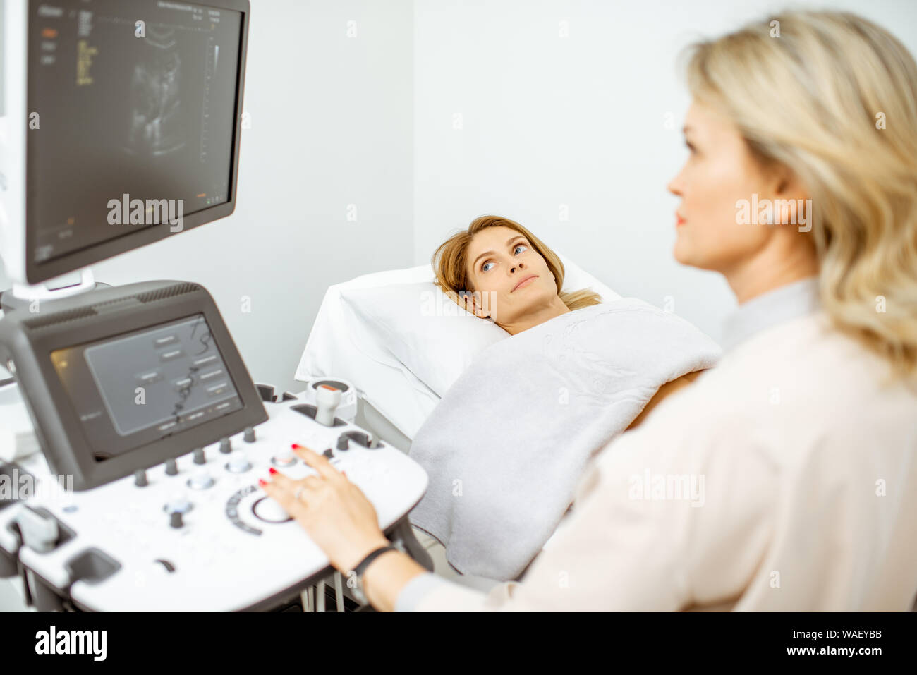 Female doctor performs ultrasound examination of a women's pelvic ...