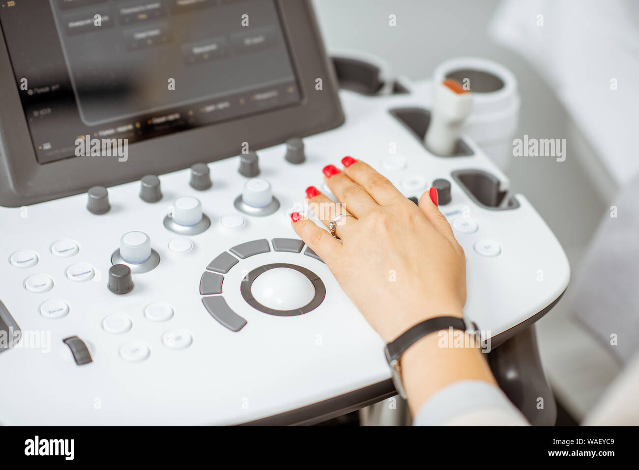 Doctor controling ultrasound machine while examining patient. Close-up ...