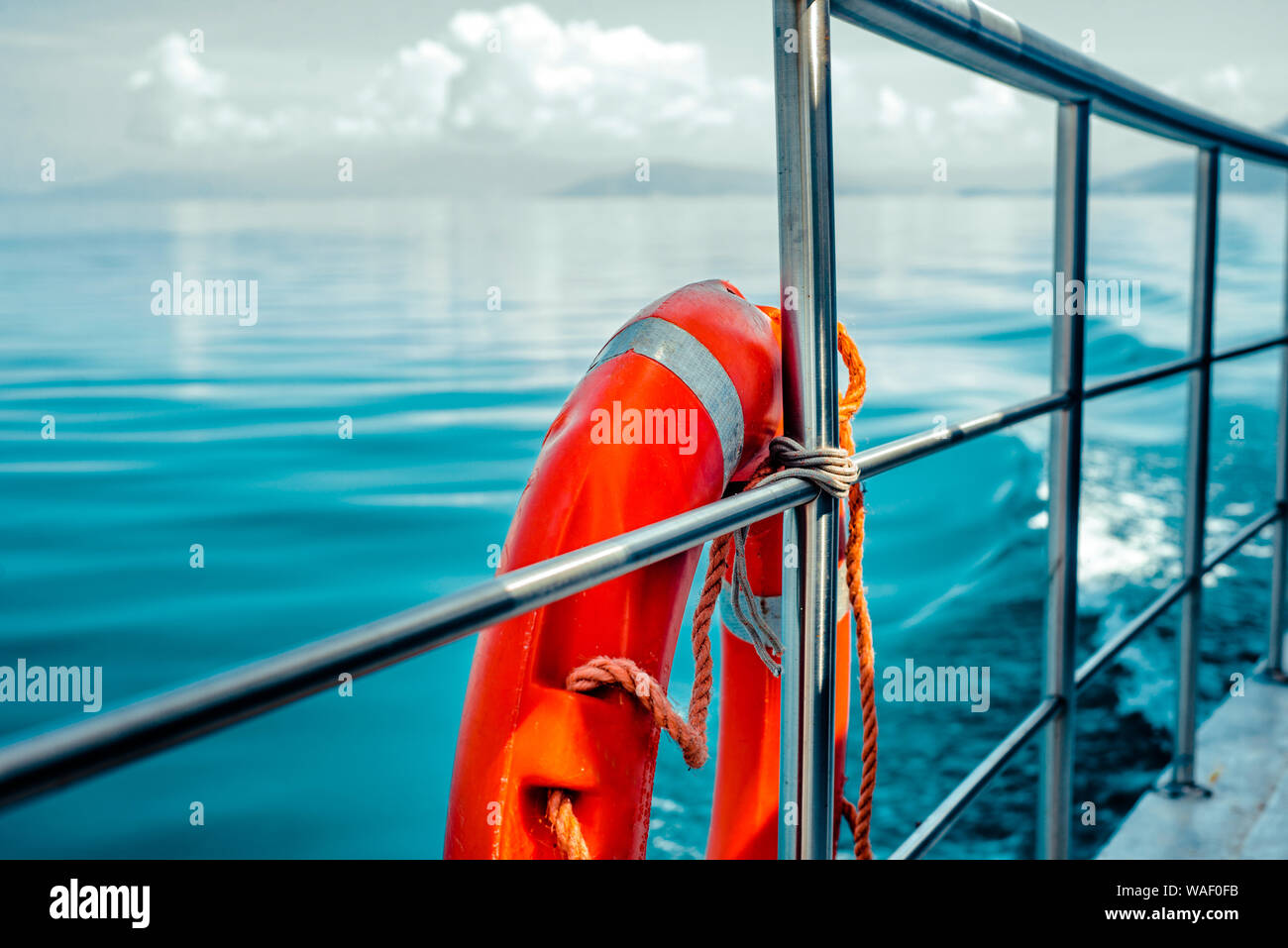 Red lifebuoy on ship railing with sea surface Stock Photo - Alamy
