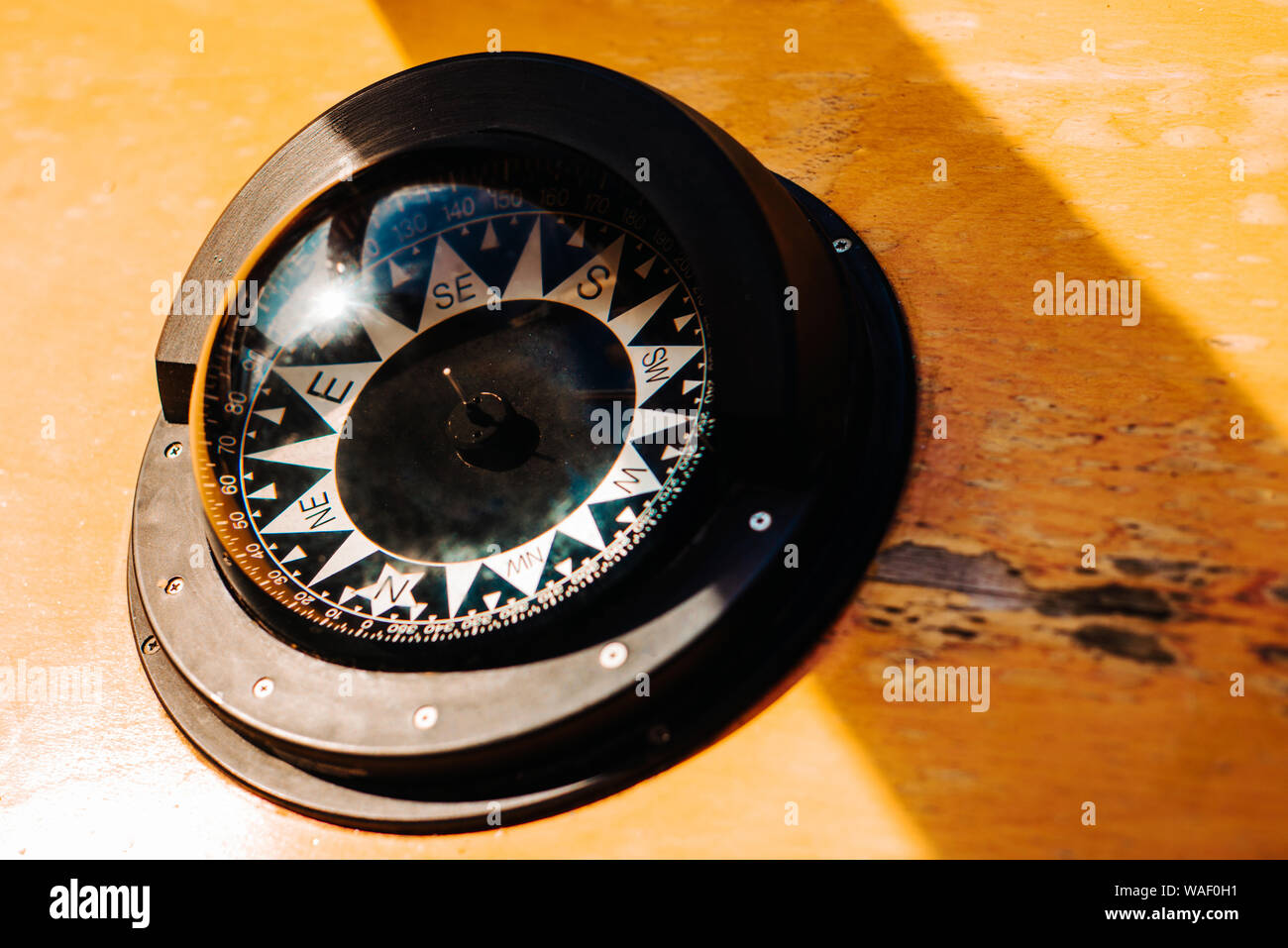 Ship black compass on wood background Stock Photo - Alamy