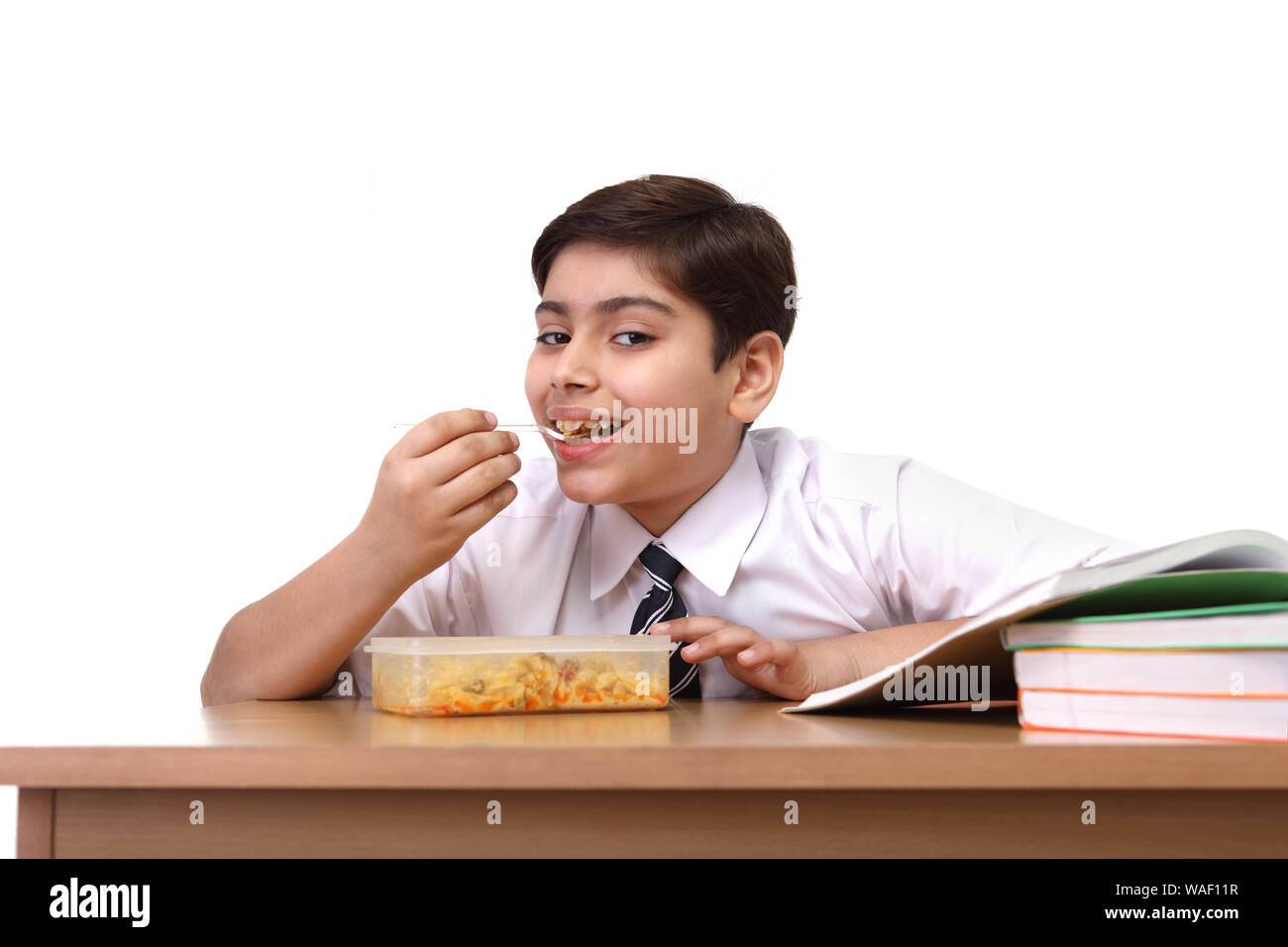 Schoolboy eating lunch in classroom Stock Photo - Alamy