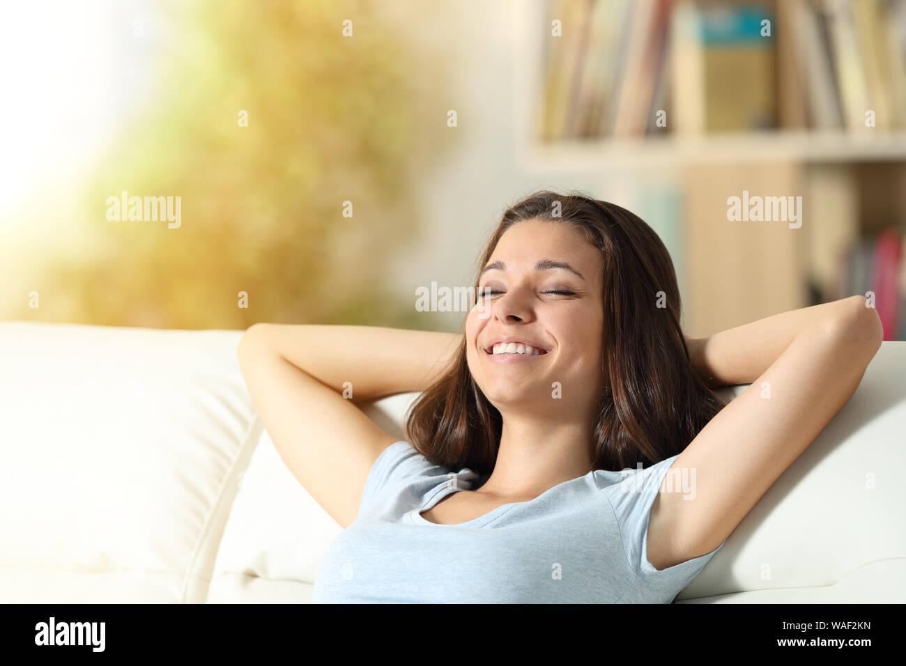 Happy relaxed girl resting sitting on a couch in the living room at ...