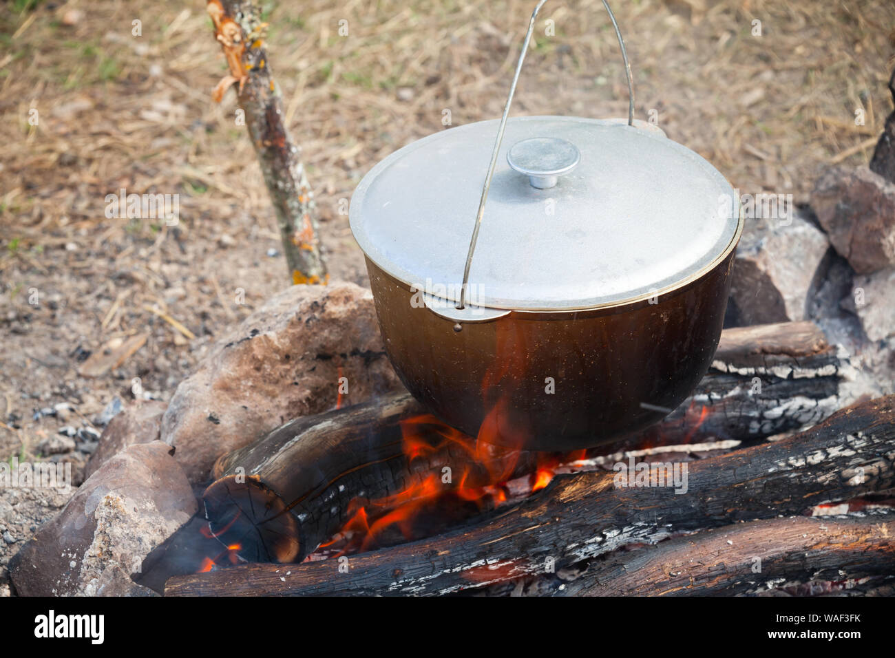 Bonfire and black cauldron. Preparing of a soup on open fire, camping ...