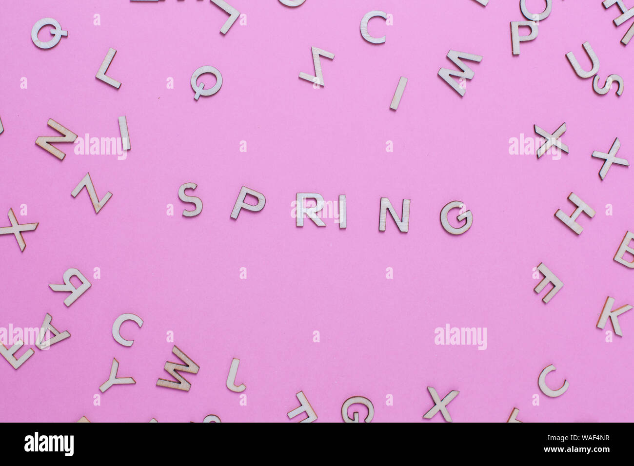 Wooden ABC alphabet letters on pink background. Spring word written ...