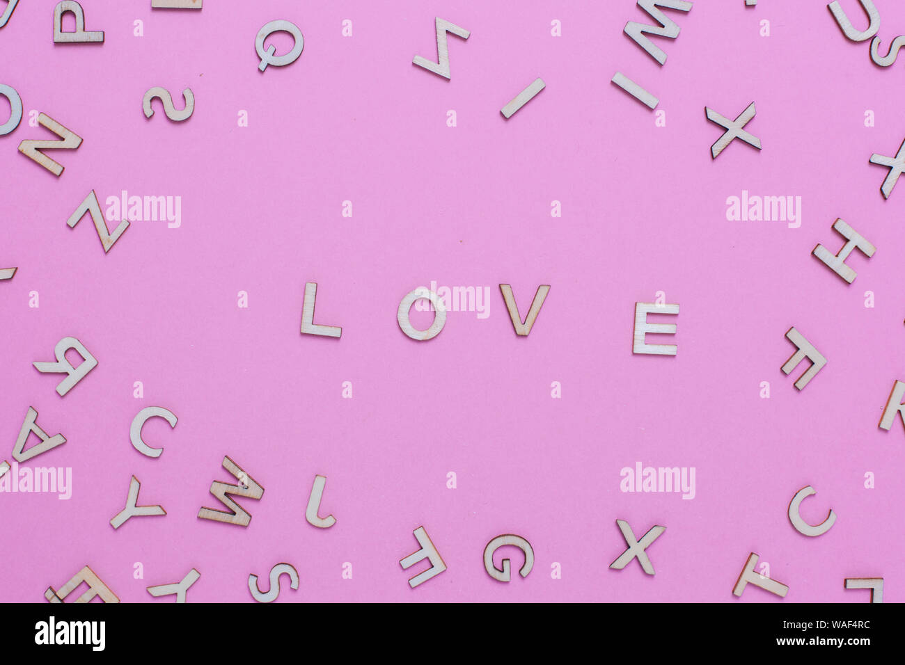 Wooden ABC alphabet letters on pink background.Love word written with ...