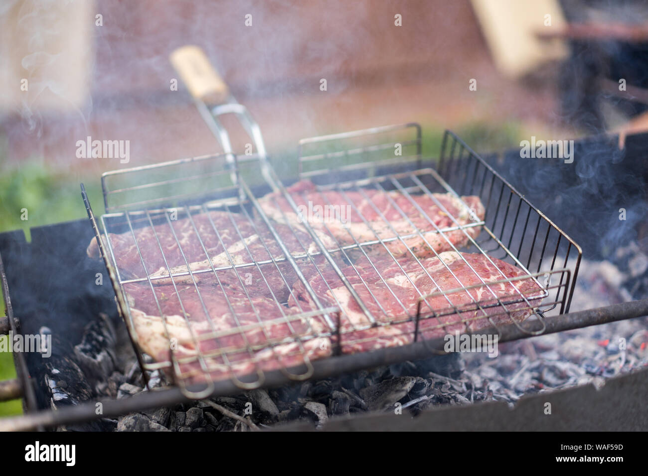 Cooking meat on barbeque grill fire outdoors. Roasting meat on metal ...
