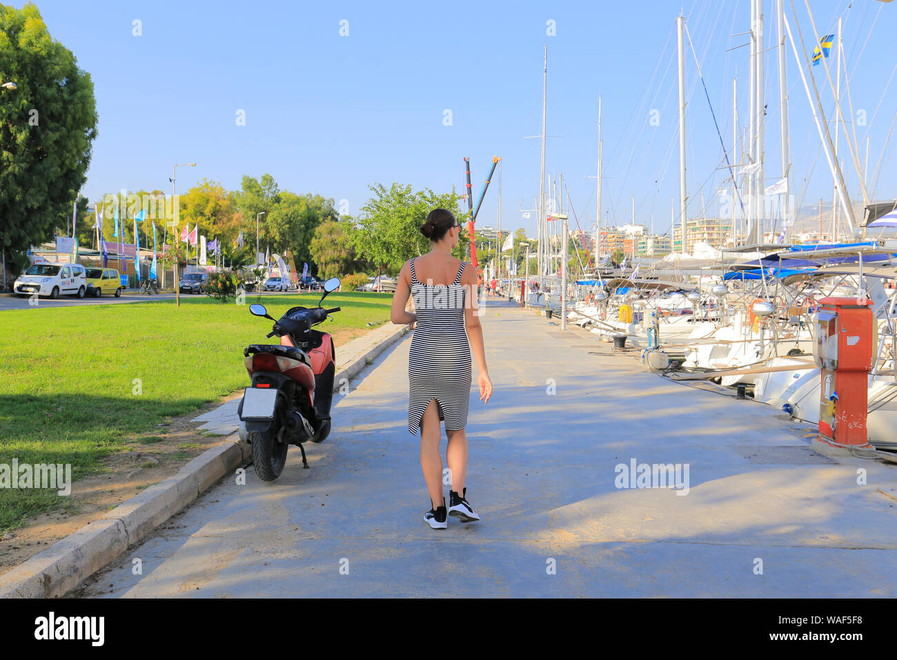 Sailor girl goes along the marina in Greece Stock Photo - Alamy
