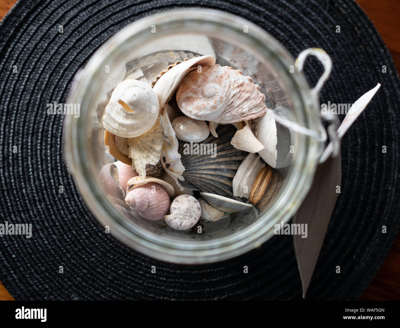 Perspective view of a glass jar full of seashells Stock Photo - Alamy