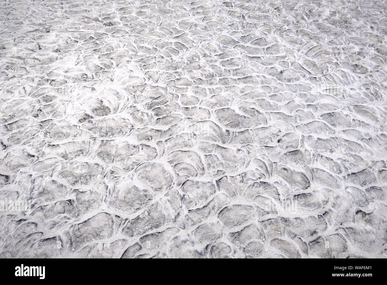 Black and white sand, structures on a sandy beach at low tide, Isle of ...