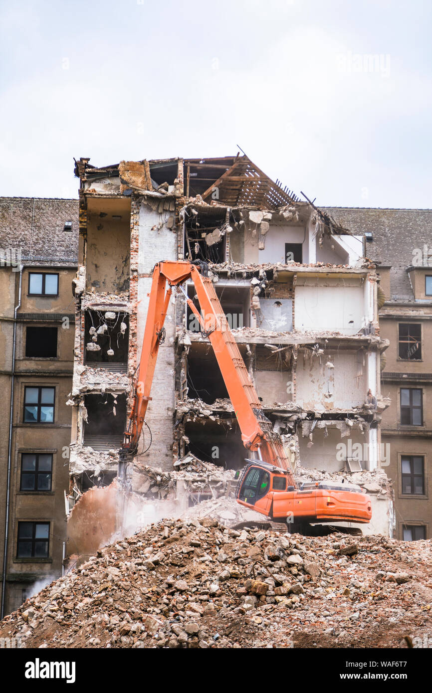 Old building demolition with hydraulic orange excavator Stock Photo - Alamy