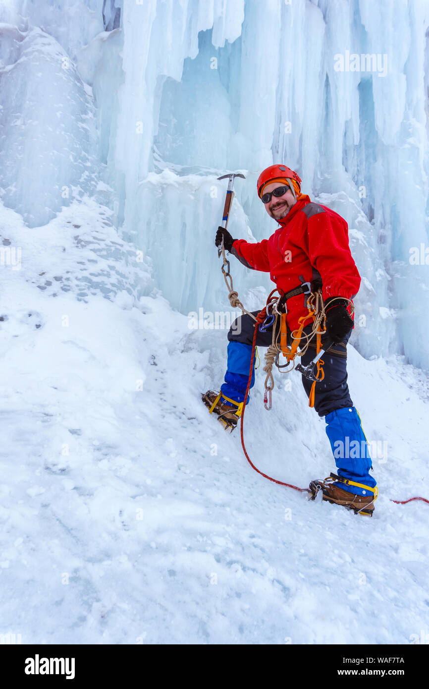 climber with ice axe storms the vertical wall of the glacier and ...