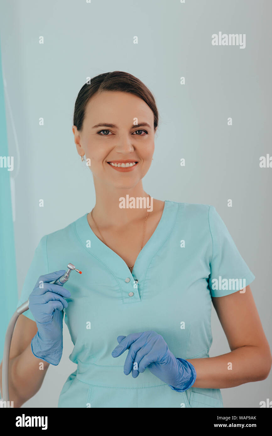 portrait positive beautiful female dentist with dental drill at dental ...