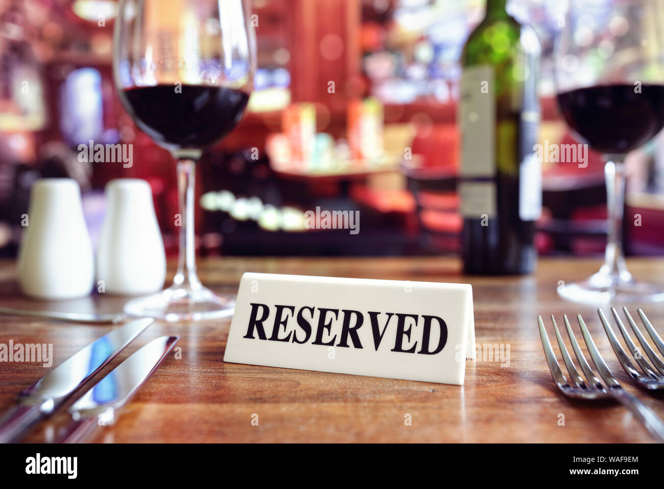 Restaurant reserved table sign with places setting and wine glasses ...