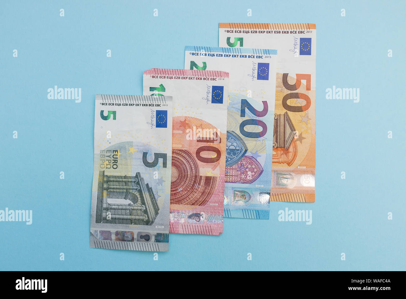 Euro currency cash bank notes money blue background Stock Photo - Alamy