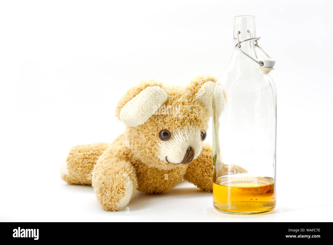 Teddy bear with a bottle of alcohol on a white background Stock Photo ...