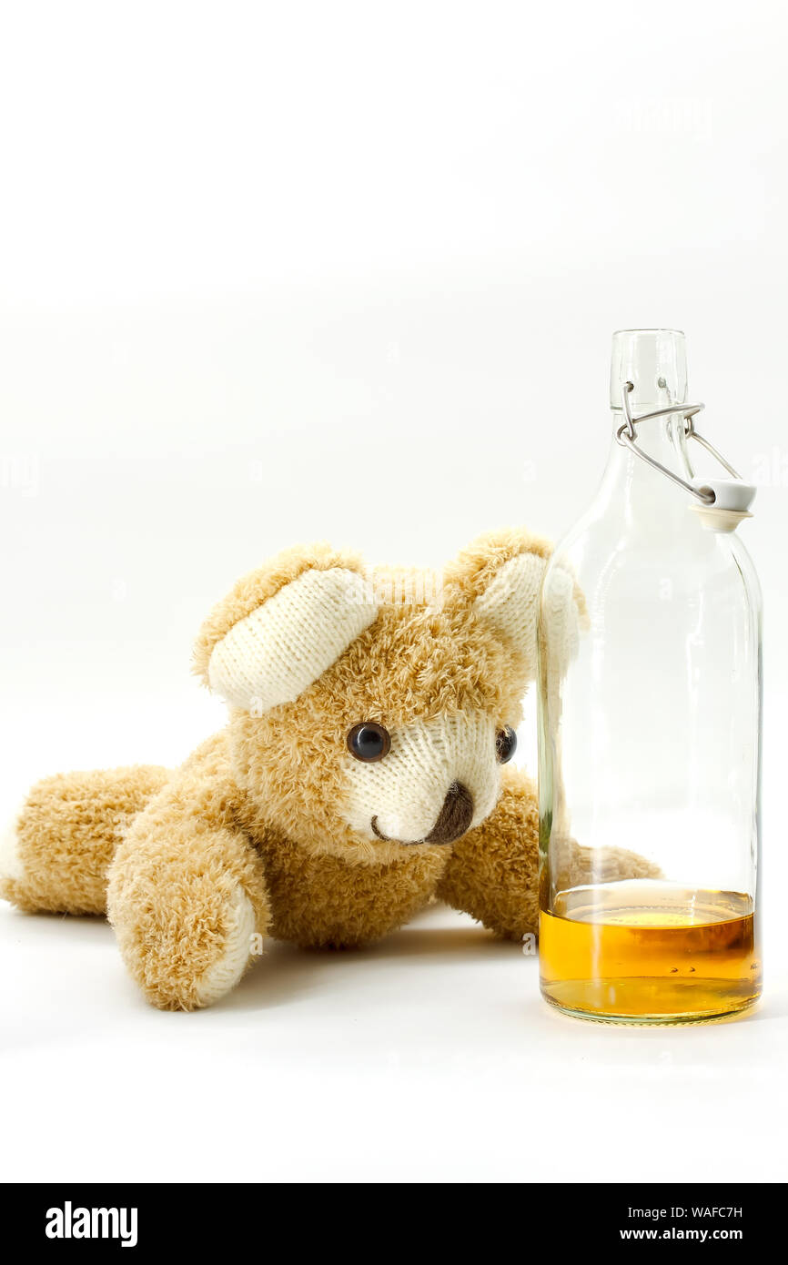 Teddy bear with a bottle of alcohol on a white background Stock Photo ...