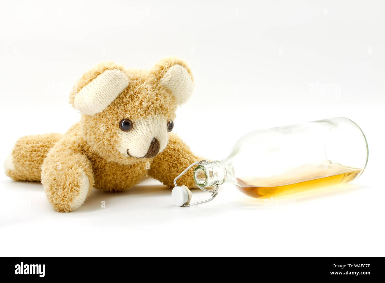 Teddy bear with a bottle of alcohol on a white background Stock Photo ...