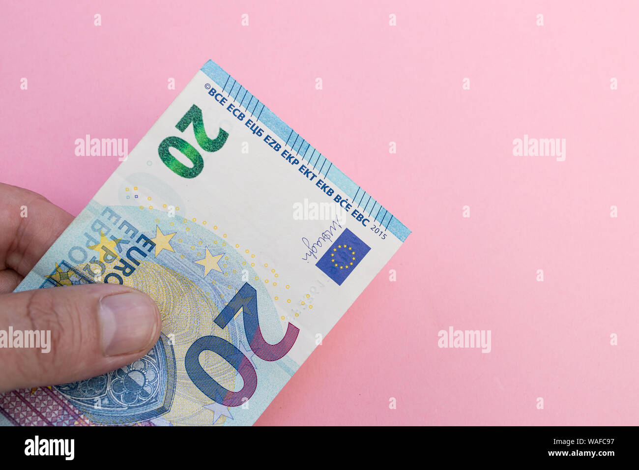 Hand holding Euro currency cash bank notes money pink background Stock ...